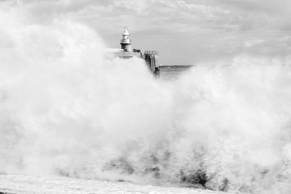 Folkestone Pier in a Storm with large waves crashing onto the beach.
